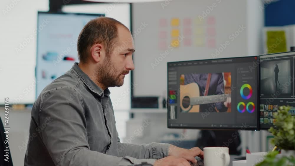 Man video editor looking at camera, working with footage and sound on ...