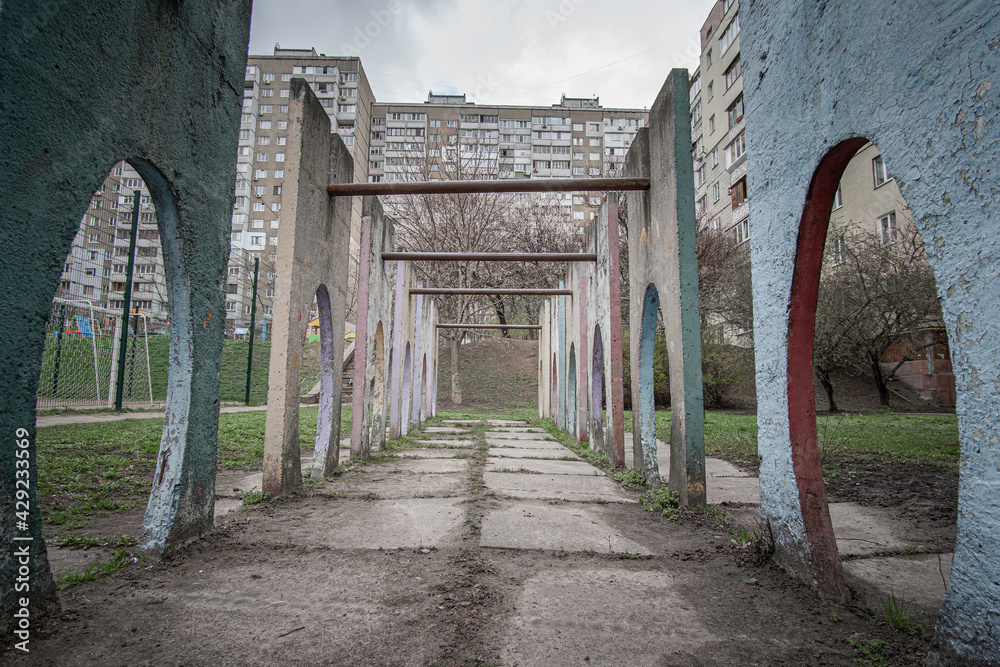 Old abandoned yard Soviet concrete playground with horizontal bars on a ...