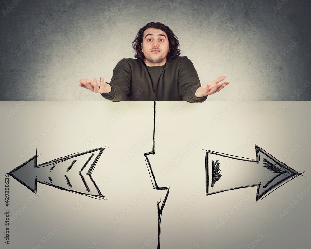Perplexed and confused man, has to choose a side, as stands behind a ...