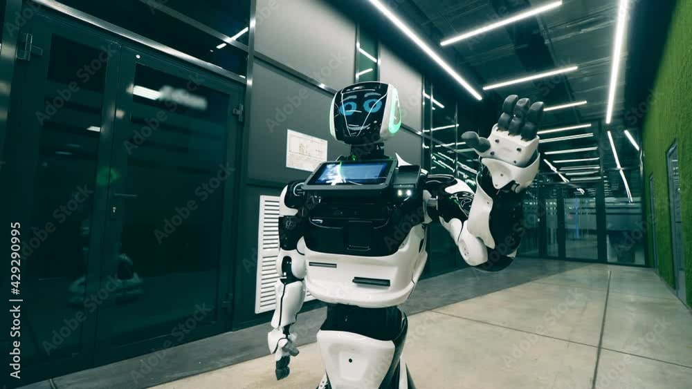 Cheerful cyborg is moving its arms while being in the business hall ...