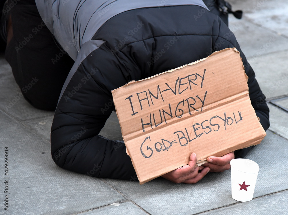 Bettler m it einem Pappschild: "I am very hungry. God bless you" Stock ...