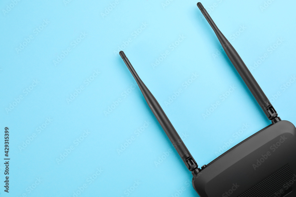 Modern Wi-Fi router on light blue background, top view. Space for text ...