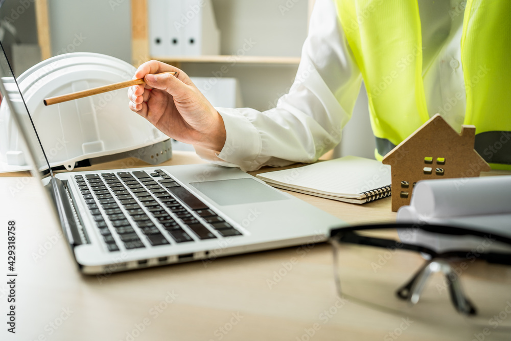 engineer wearing a safety vest using laptop computer for a think design ...