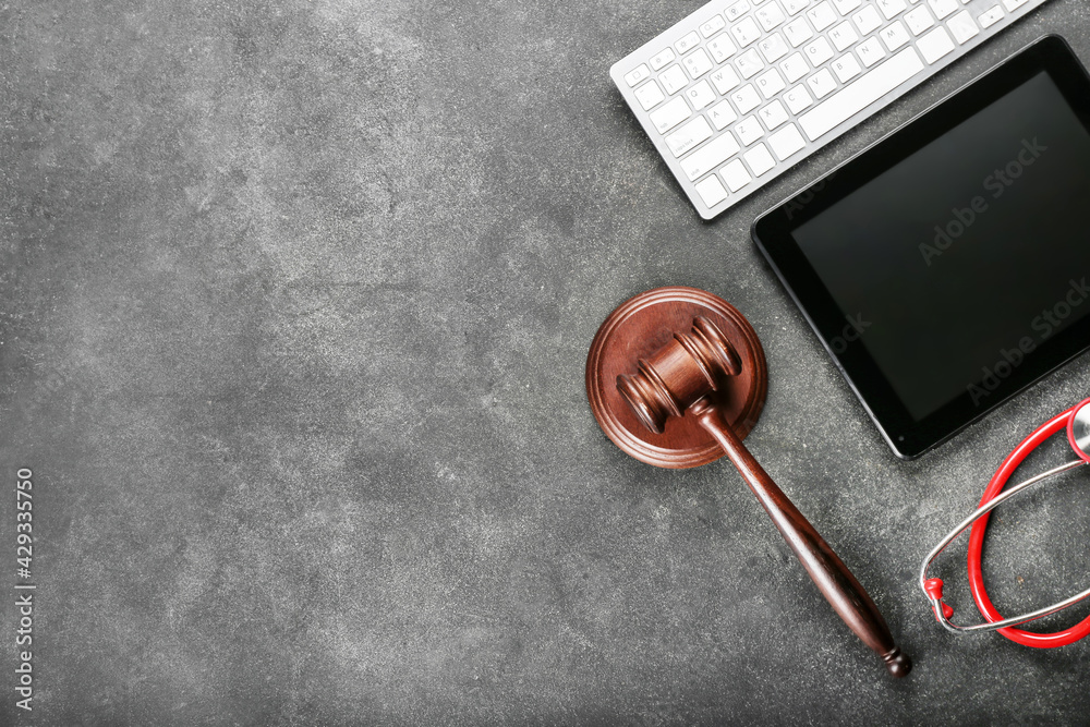Judge gavel, tablet computer, keyboard and stethoscope on grey ...