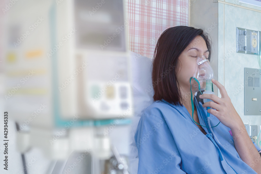 Sick beautiful female in blue cloth hold nasal mask with respiratory ...