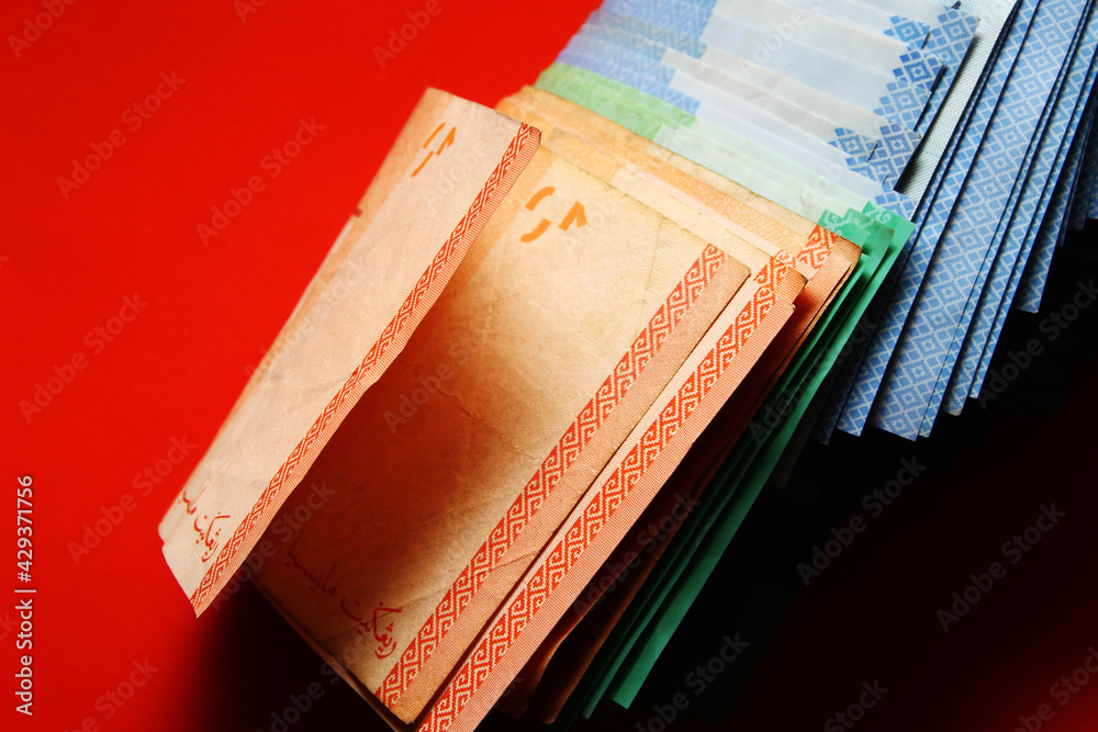 Stack of Malaysia Ringgit banknotes on red background Stock Photo ...