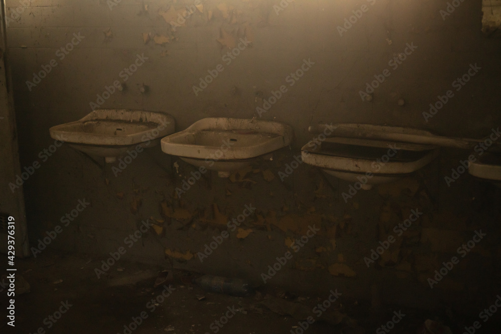 Old, neglected taps in the public restroom inside abandoned brick and ...
