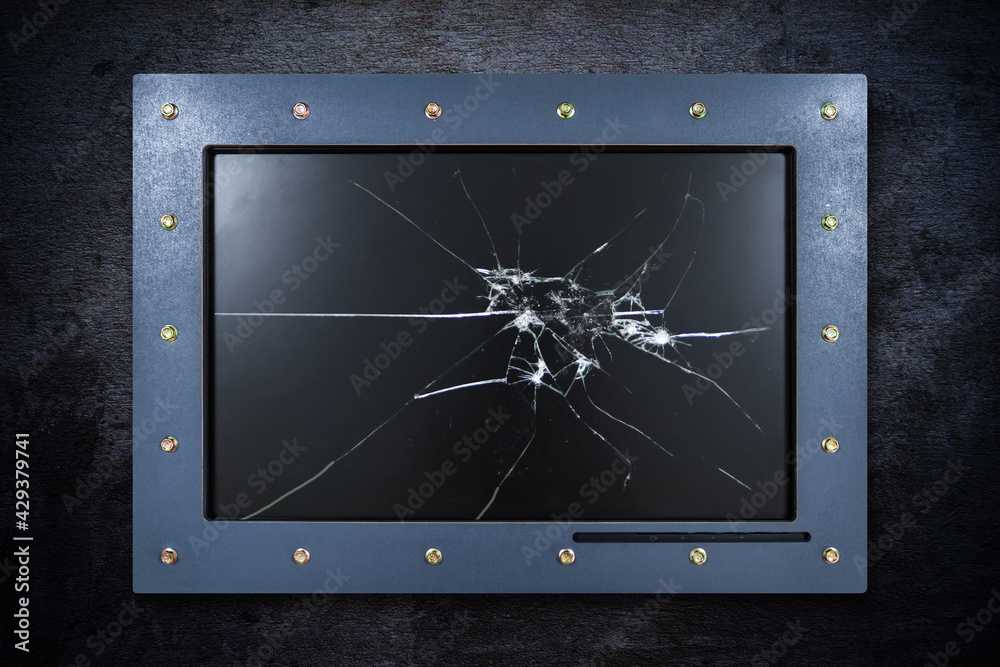 Old grunge monitor in the frame of metal rivets on a concrete dark ...