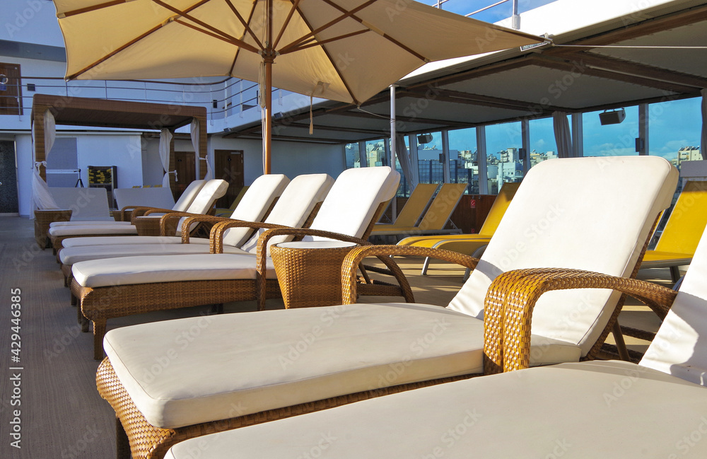 Luxury sun loungers and deck lounge chairs on outside terrace, patio or ...
