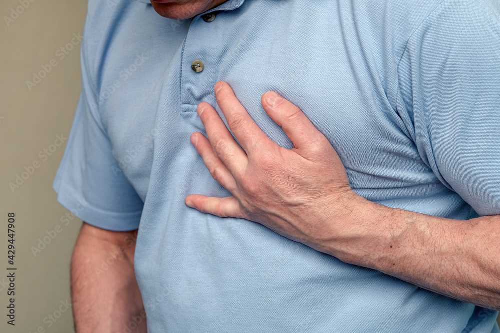 Heart pain, a person grabbing the heart area with his hand, suffering ...