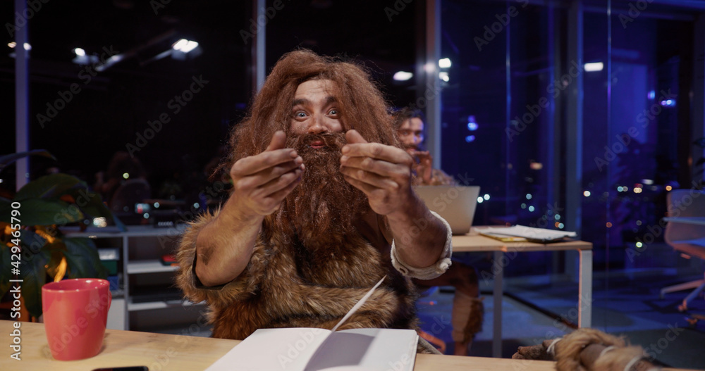 Portrait face of caveman in furry clothes yelling at camera pointing ...