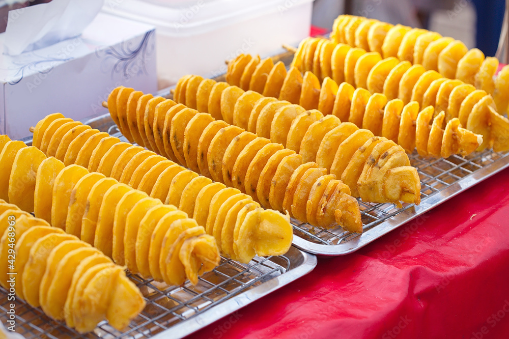 Deep fried twisted potatoes on tray for selling in street food market ...