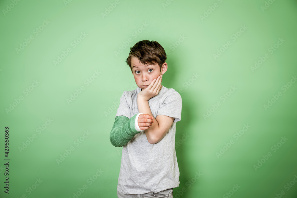 cool young schoolboy with broken arm and green arm plaster posing in ...