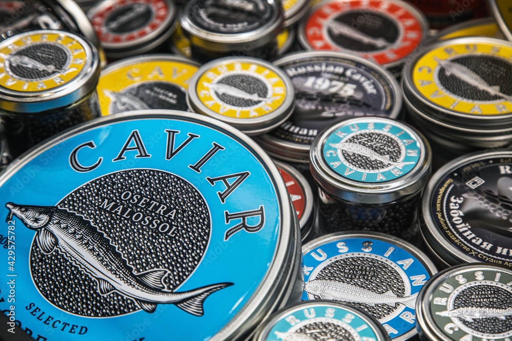 caviar of different varieties in tin cans on the counter in a fish ...