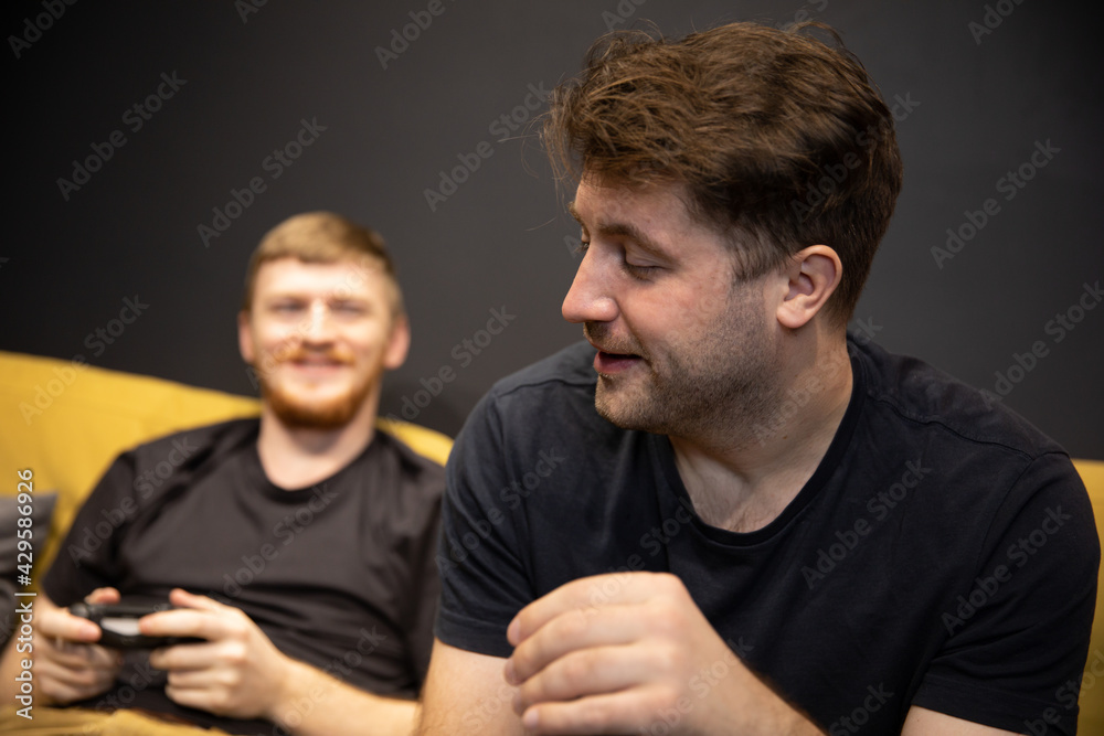 two handsome guys play passionately video game holding console ...
