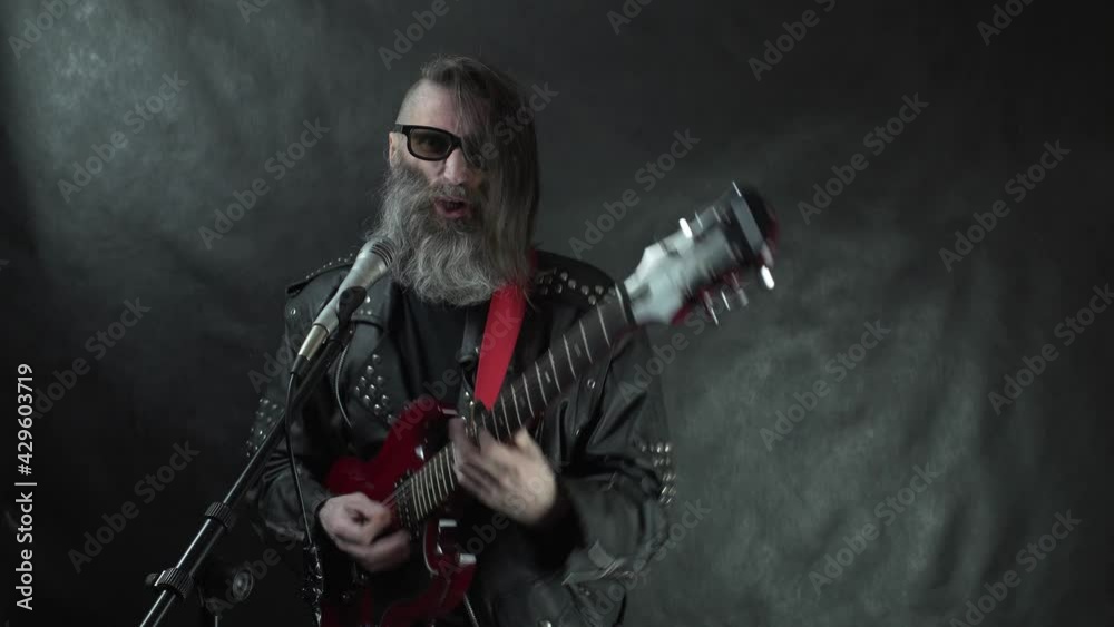 Bearded hairy rocker in retro black sunglasses with shaved temples and ...