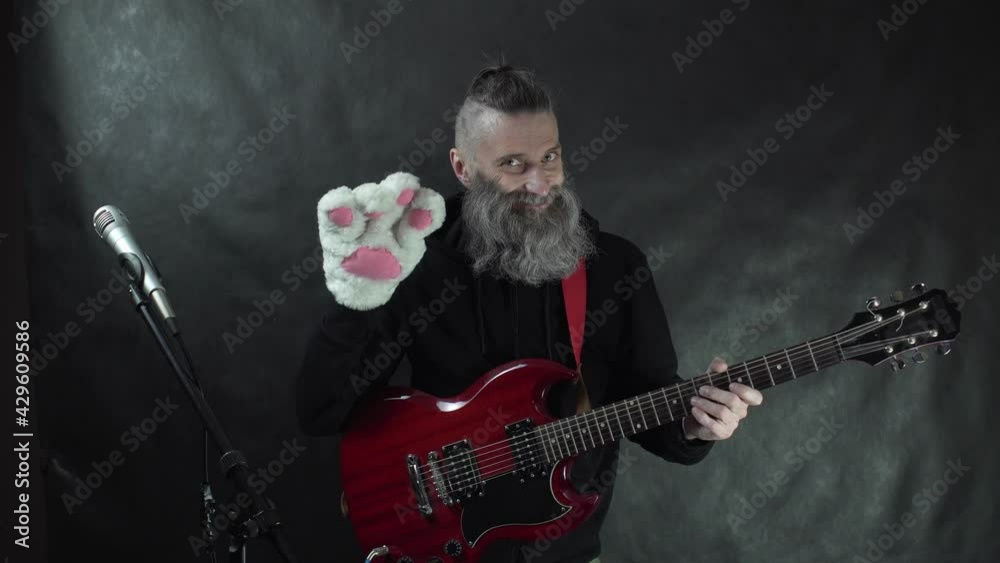 Bearded rocker with shaved temples in black hoodie smiling and waving ...
