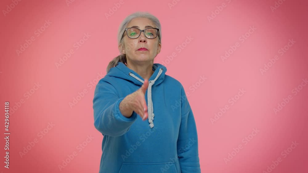 Friendly senior good-looking granny woman outstretching hand to camera ...