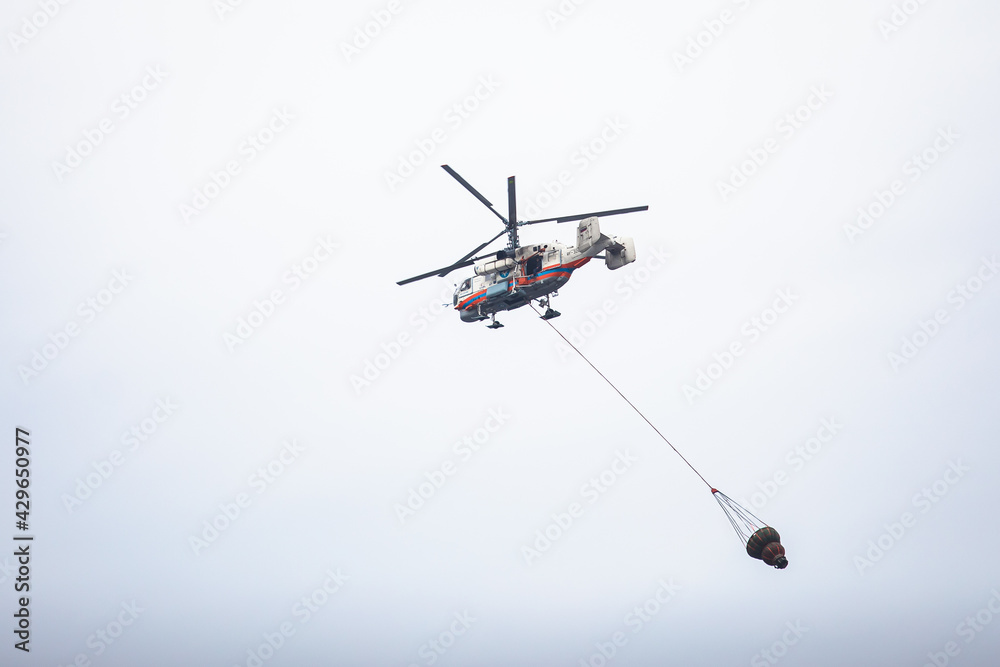 Fire fighting helicopter silhouette with bambi bucket for сarrying ...