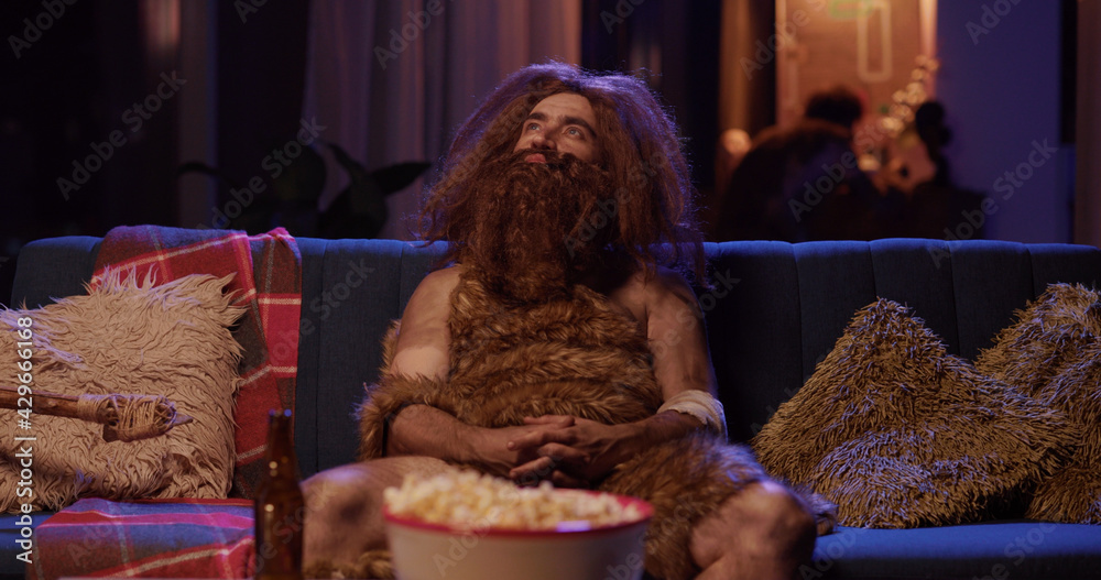 Portrait of funny ancient prehistoric primitive human in animal fur ...