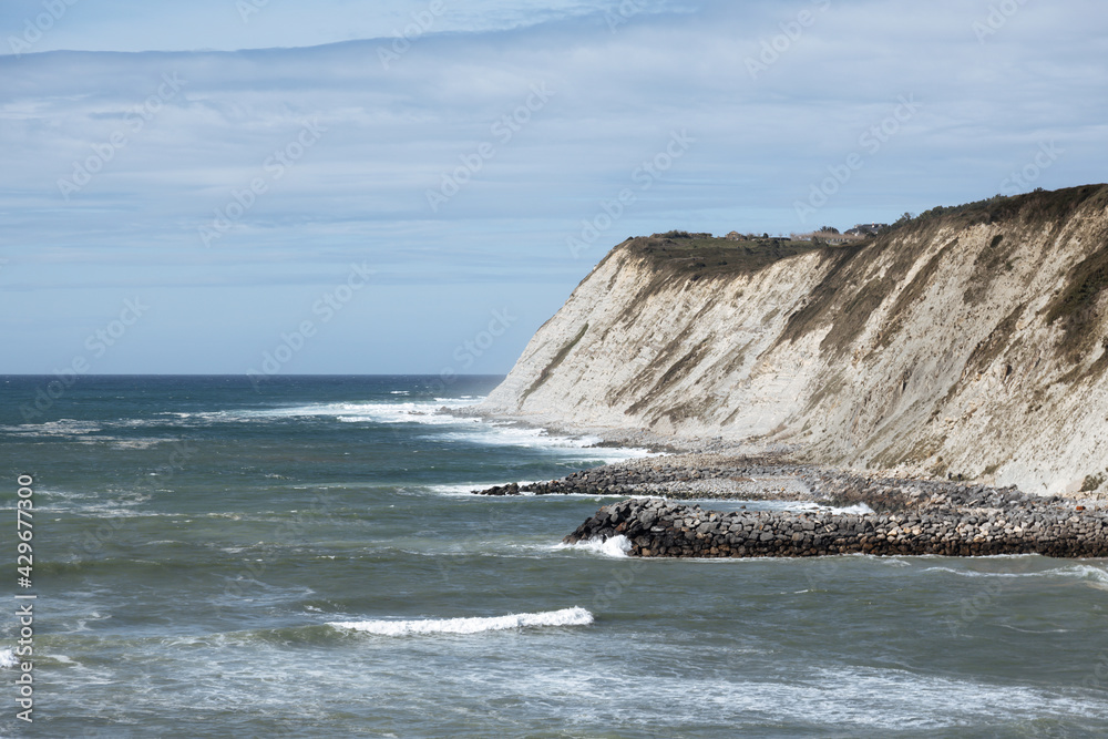 Rocky island mountains meet the beautiful blue of the ocean in Basque ...