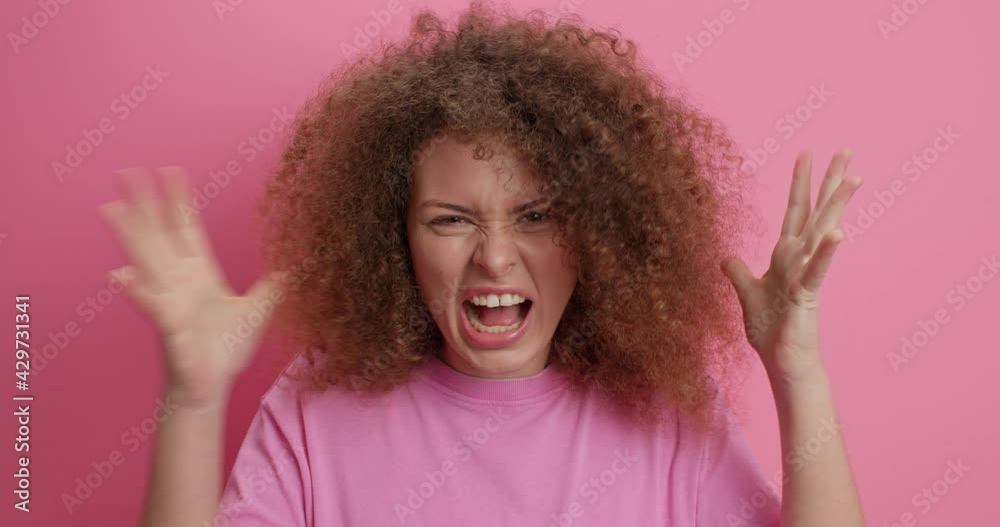 Emtional Outraged Woman With Curly Hair Screams From Anger Shakes Hands