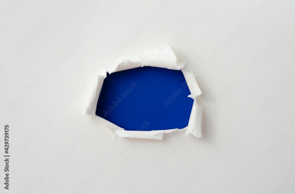 torn paper with the curled ripped sides. a blue hole of torn on the ...