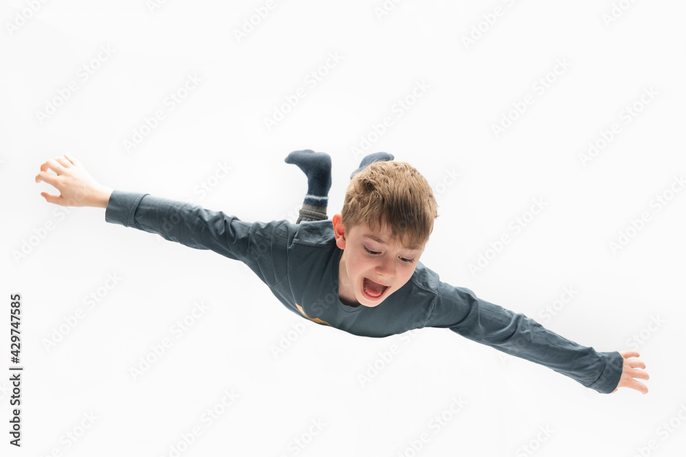 Boy flies like an airplane isolated on white background. Flying in ...