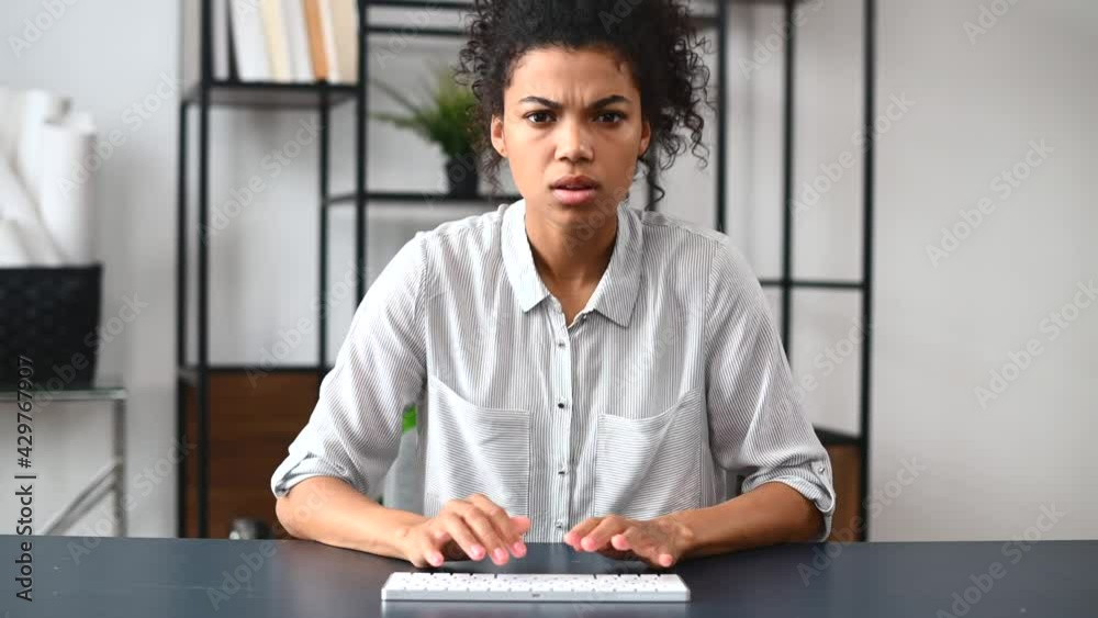Frustrated young African American female office worker typing then ...