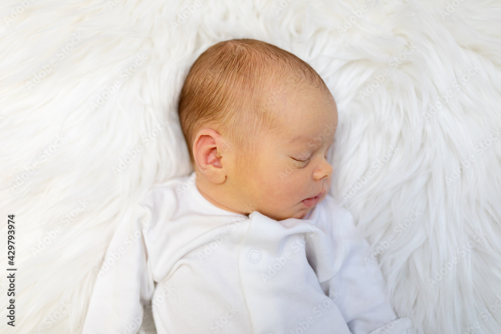 Adorable newborn one week age in white bedroom. Newborn child relaxing ...