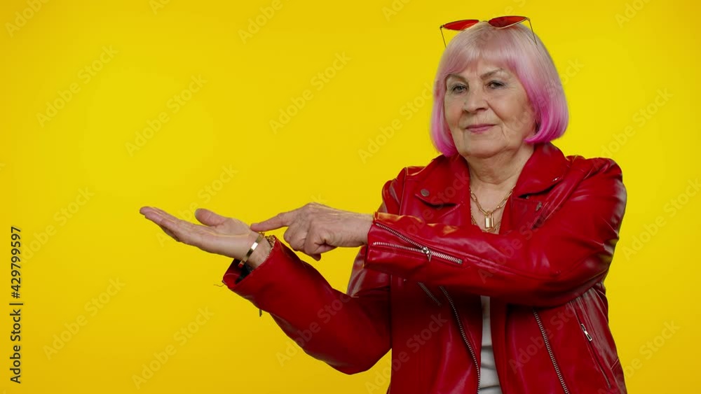 Senior old granny woman with pink hair in leather red jacket showing ...