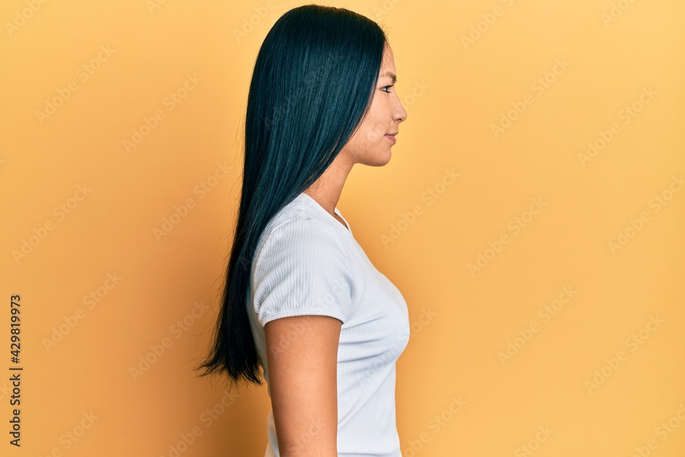 Beautiful hispanic woman wearing casual white tshirt looking to side ...