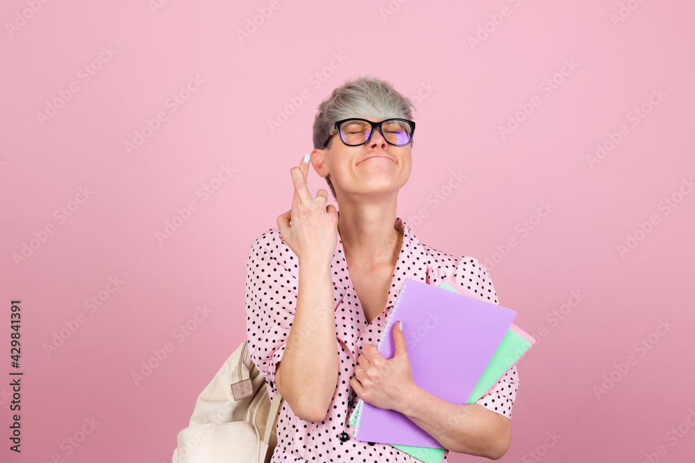 Stylish woman in dress and glasses on pink background with notebooks ...