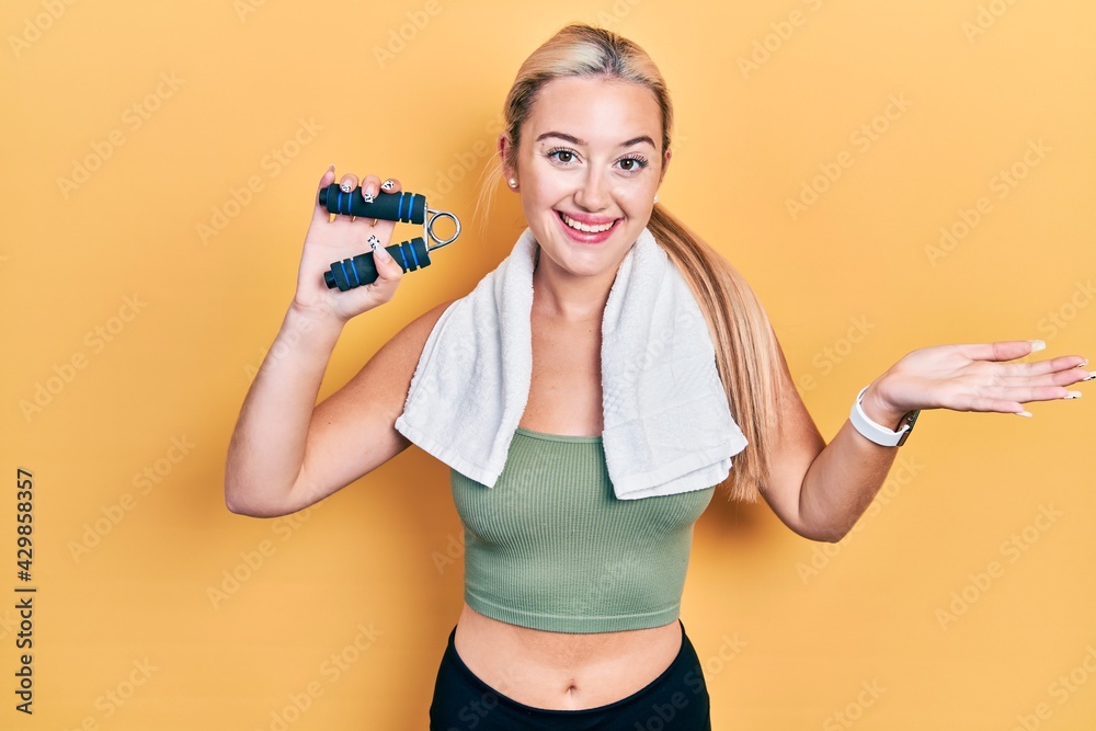 Young blonde girl training muscle with hand grip celebrating ...