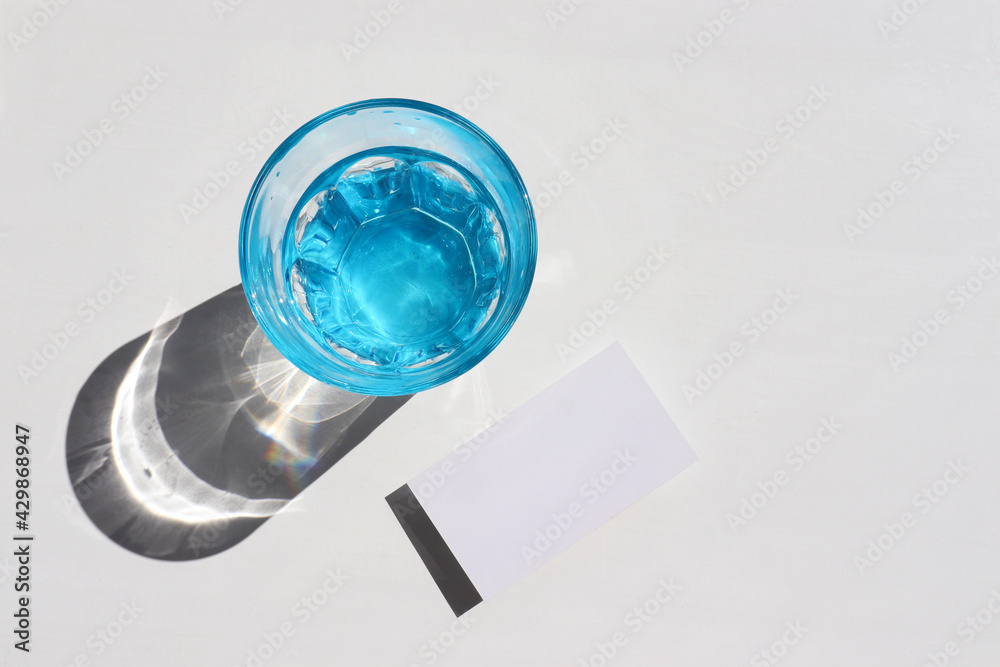 Summer still life with fresh glass of water and blank paper card on ...