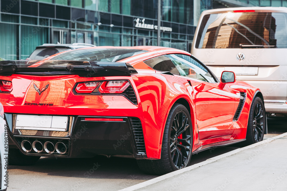 Red Chevrolet Corvette C7 parked along the street. Back view of mid ...