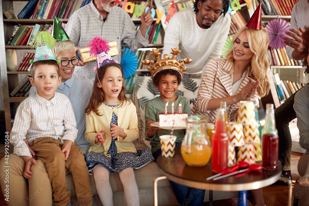 Family and friends having a good time at kids birthday party at home ...