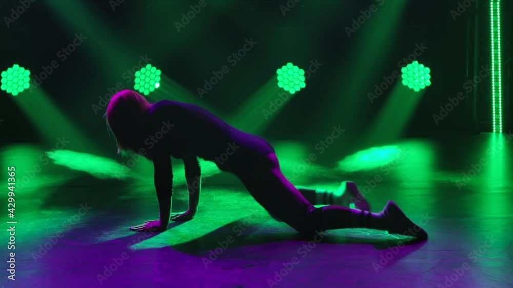 Flexible young woman moves her ass, dances twerk in a black leotard ...