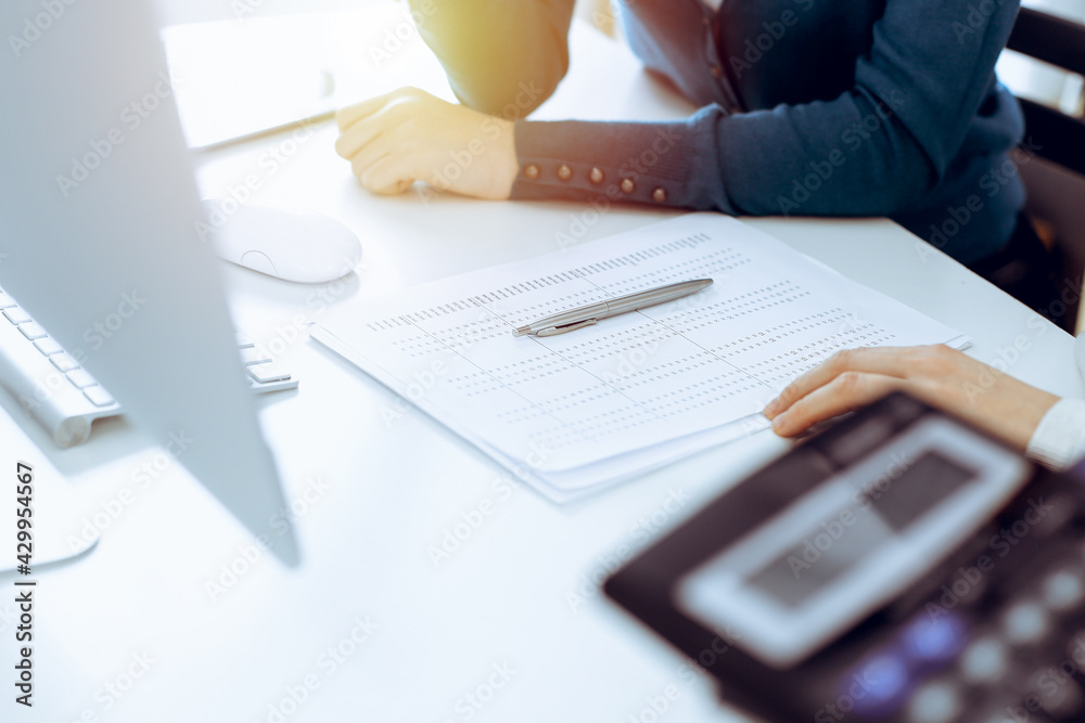 Accountant checking financial statement or counting by calculator ...