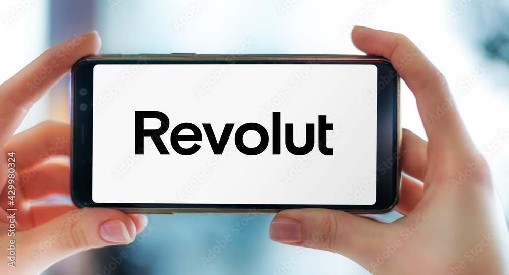 Hands holding smartphone displaying logo of Revolut Stock Photo | Adobe ...