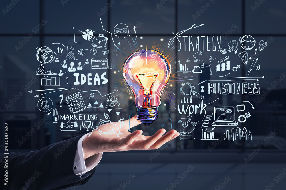 Businessman hand holding hologram of colorful light bulb as a concept ...