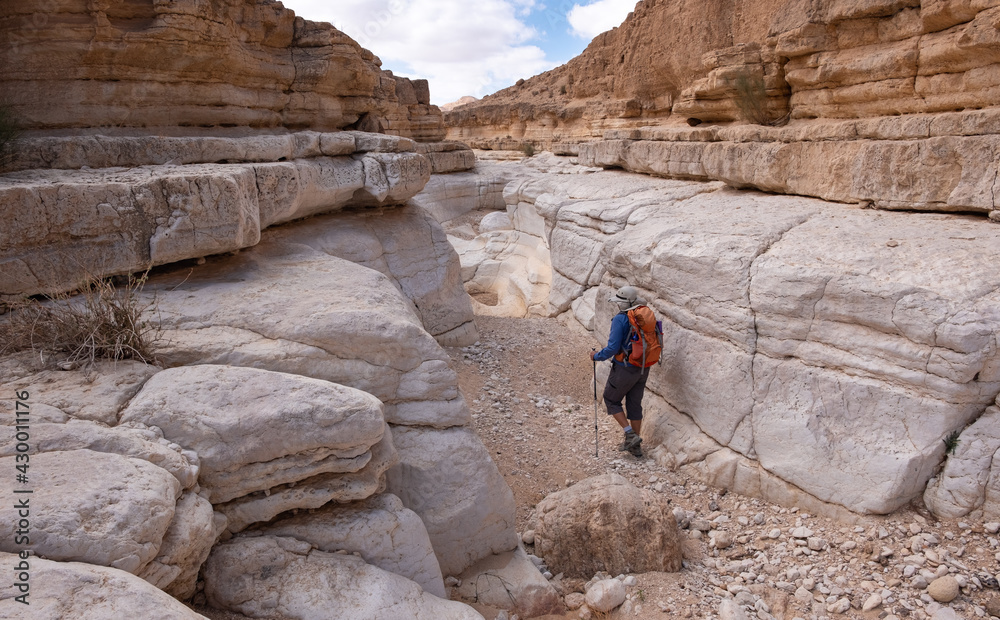 Female hiker on a hiking trail inside a dry wadi Hava in a remote ...