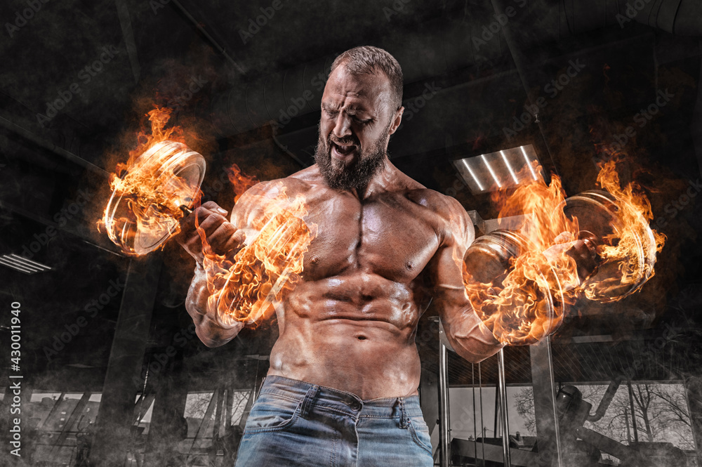Professional athlete trains with fire dumbbells in the gym. Bicep ...