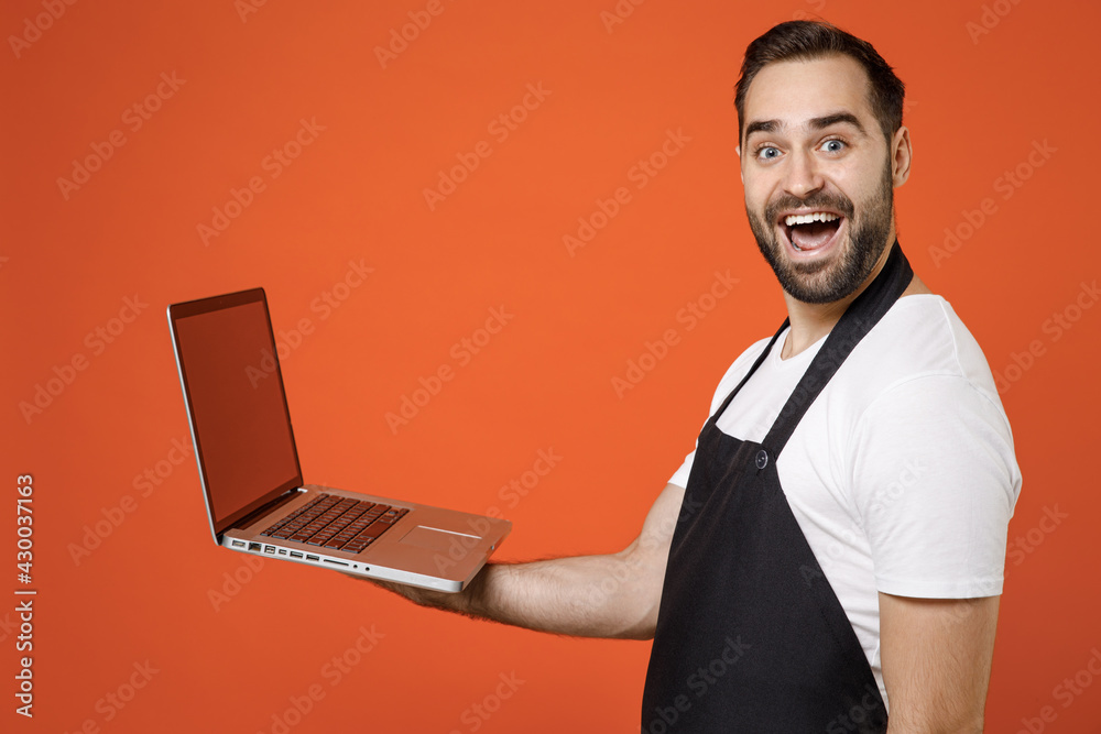 Side view young man barista bartender barman employee in black apron ...