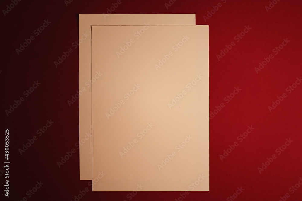 Blank A4 paper, beige on dark red background as office stationery ...