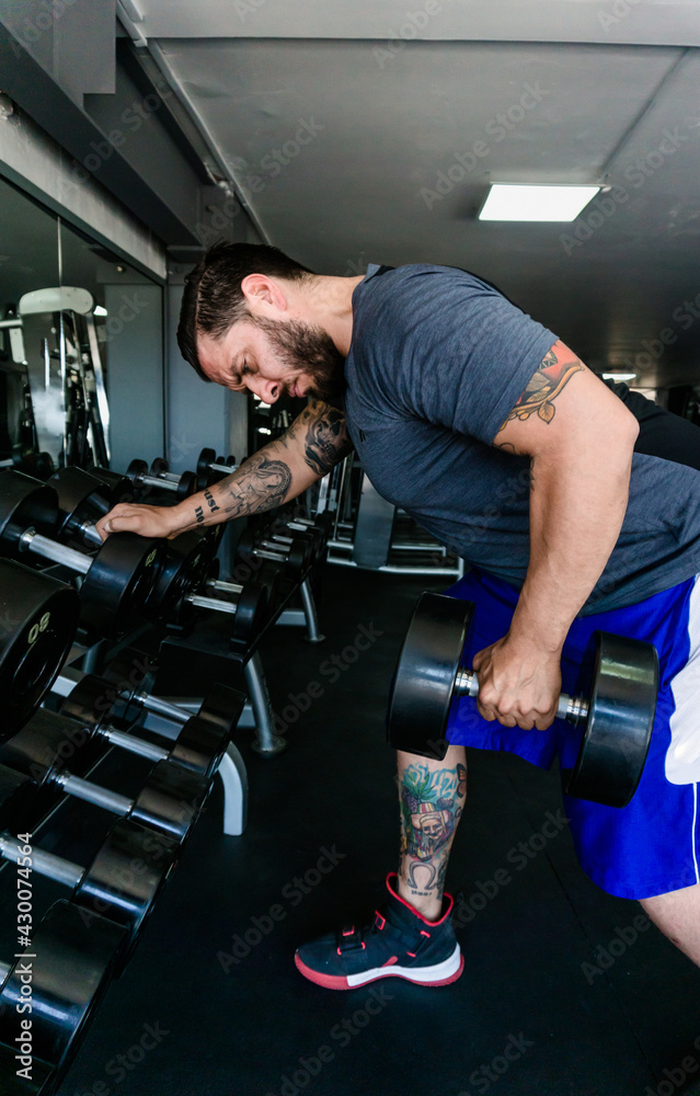 muscular man performing back exercises with weights in gymnasium Stock ...