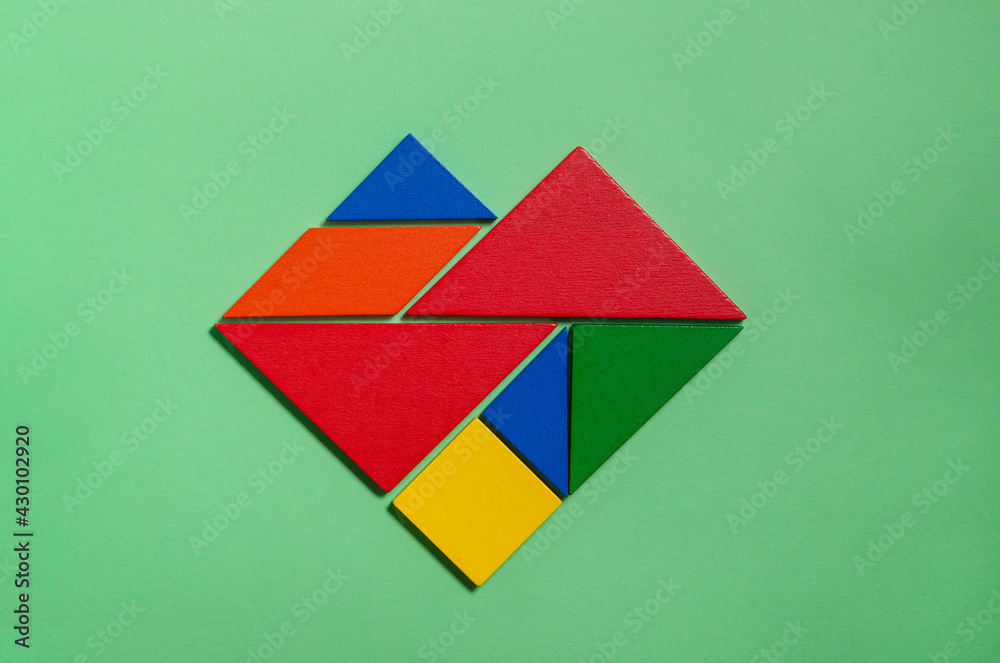 Heart of colorful tangrams in green background Stock Photo | Adobe Stock