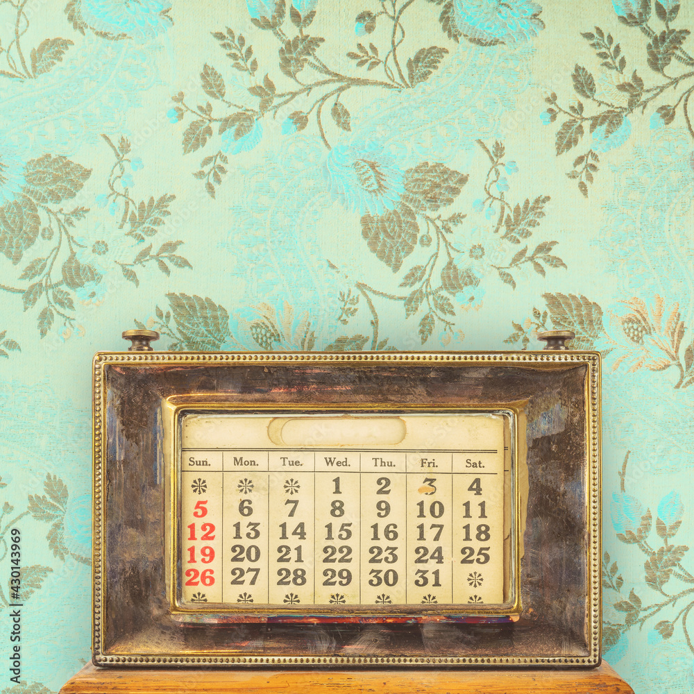 Ancient office table calendar in front of vintage blue wallpaper with ...