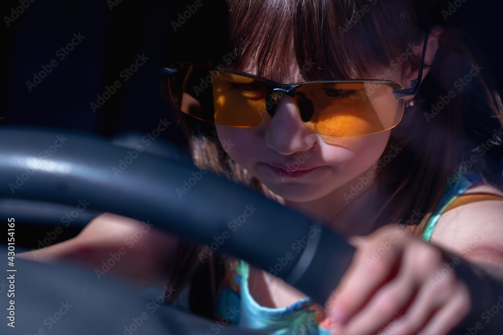 Dangers and risks of underage driving. Portrait of little child girl ...