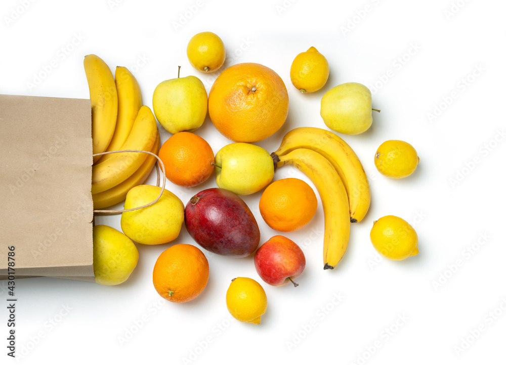Top view of natural fresh fruits sprinkled from a paper bag on a white ...